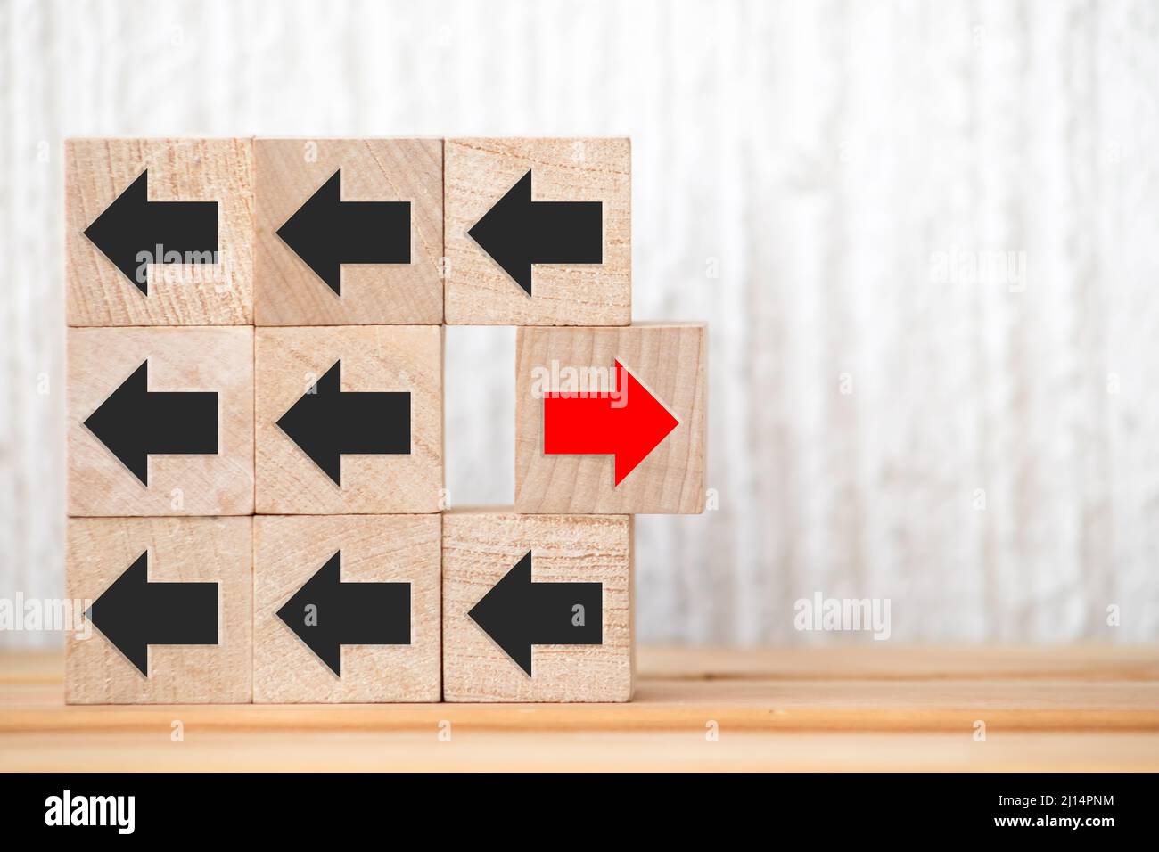 Wooden block with red arrow facing the opposite direction black arrows ...