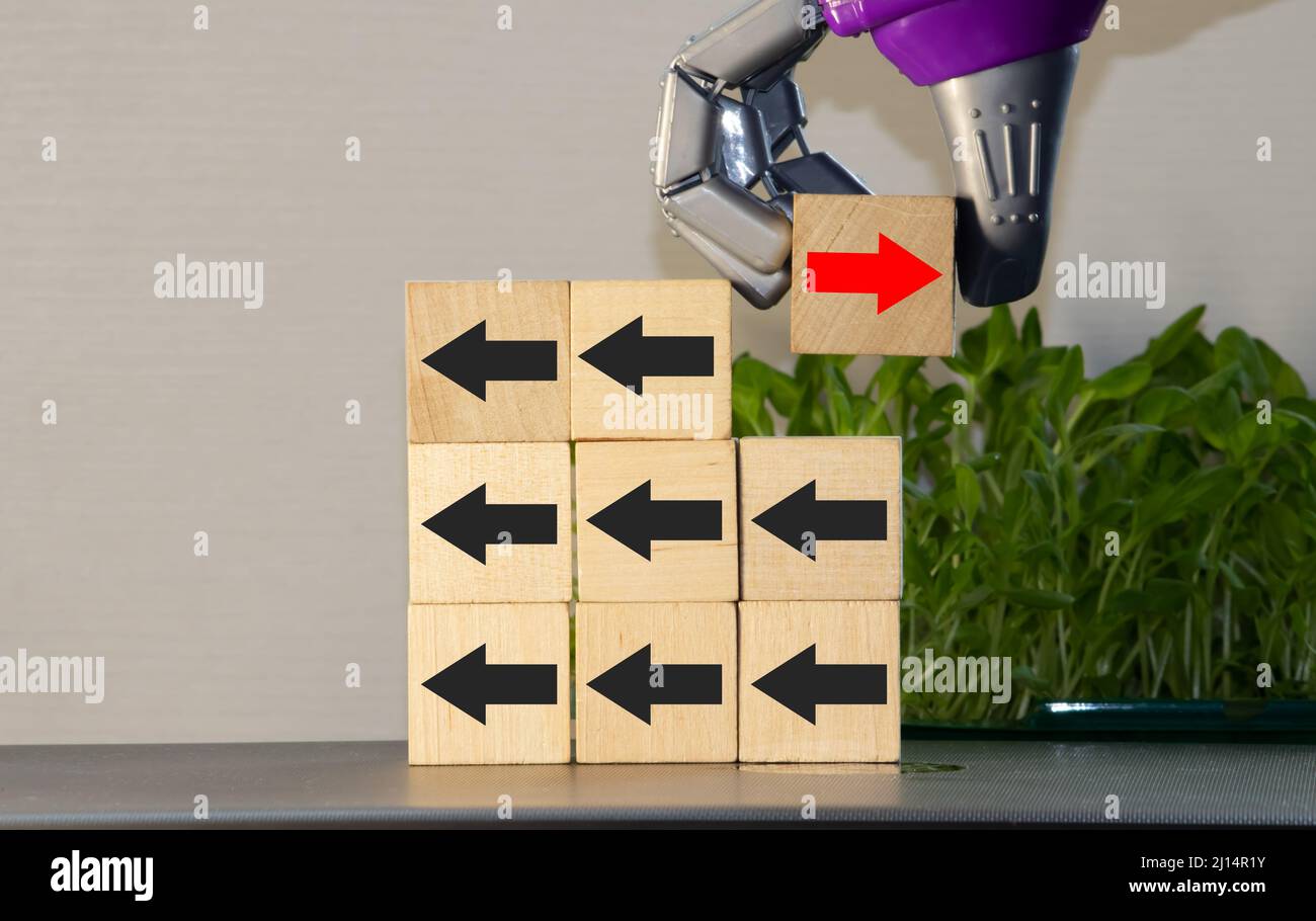 Hand picked wooden block with red arrow facing the opposite direction ...