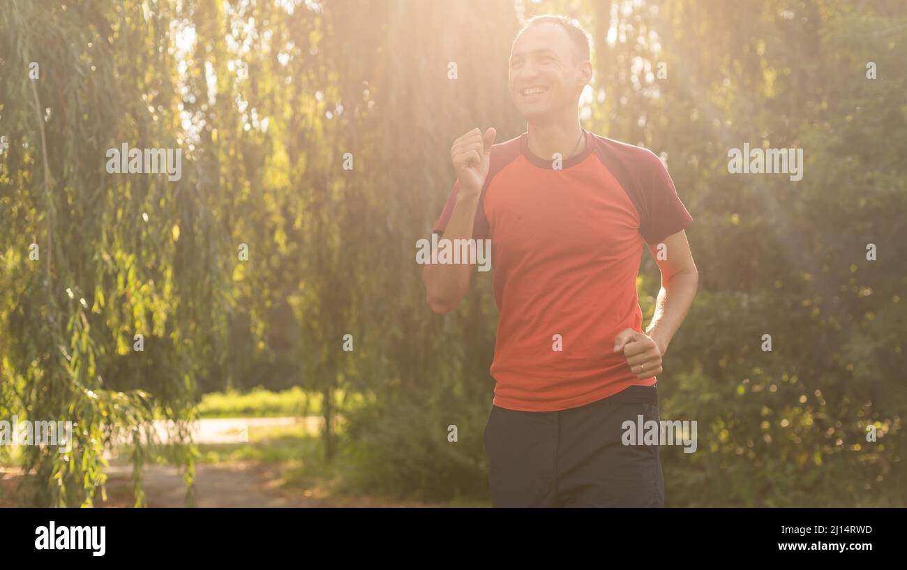 Portrait of a man running in a park. Close up of a smiling man running ...
