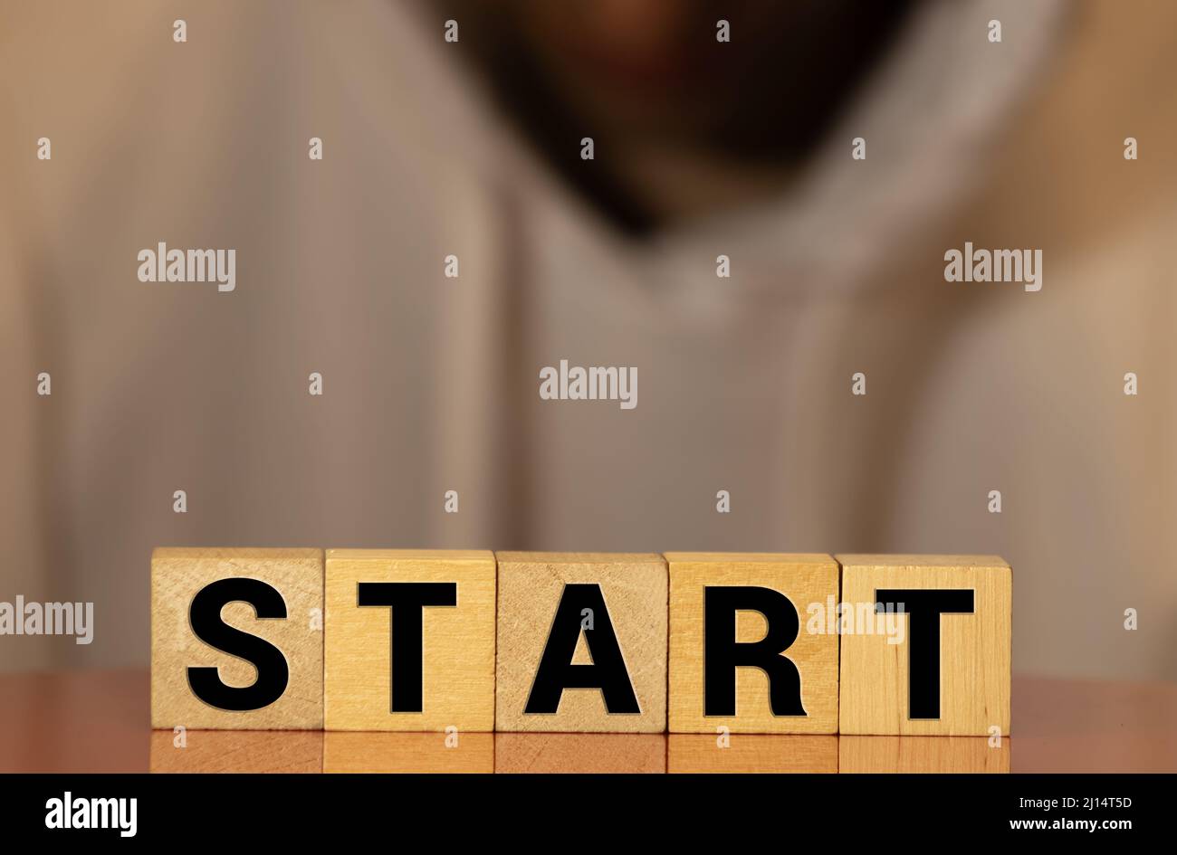 Start word on wooden cube blocks on a grey background Stock Photo - Alamy