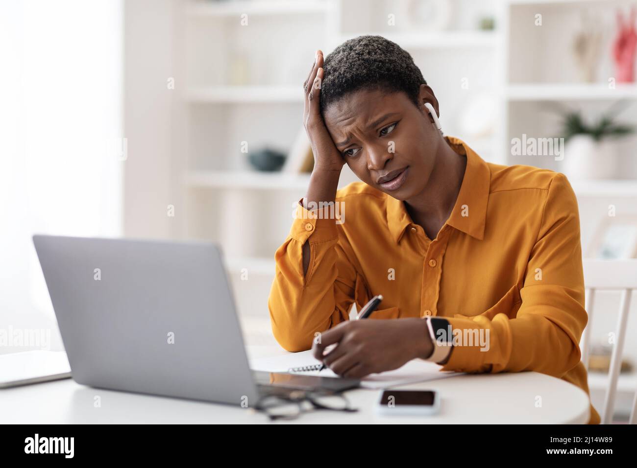 Bored black lady attending webinar, sitting in front of laptop Stock ...