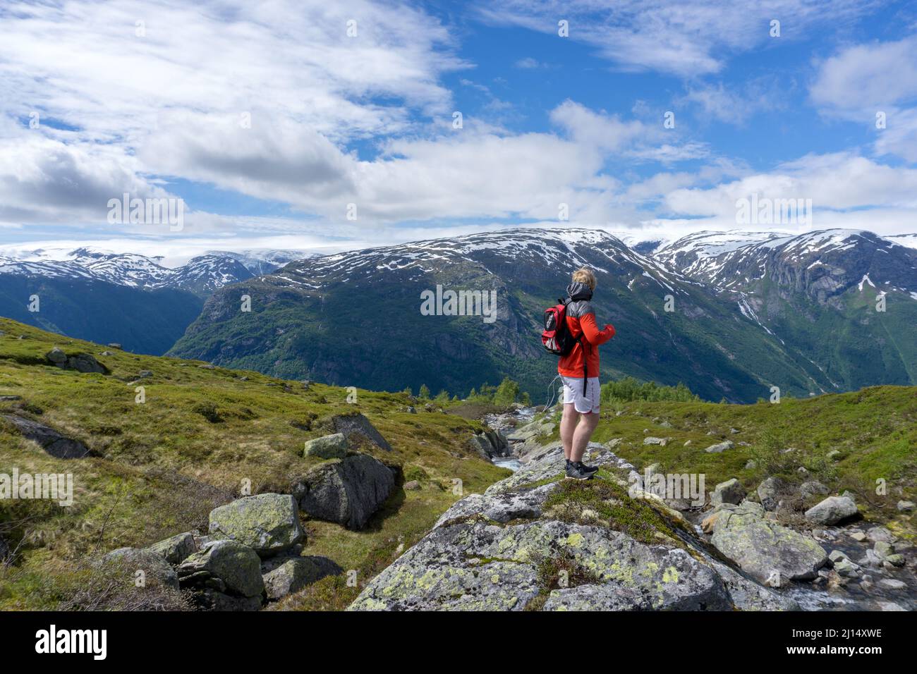 View of a mountain climber on top of the hill with a backpack on a ...