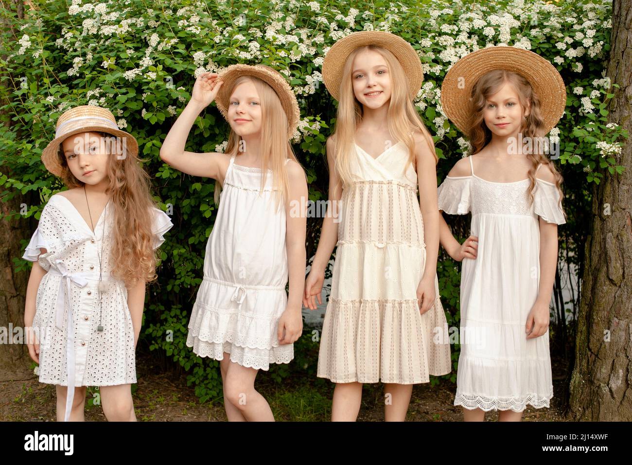Cheerful tween girls posing in green garden near flowering shrub Stock ...