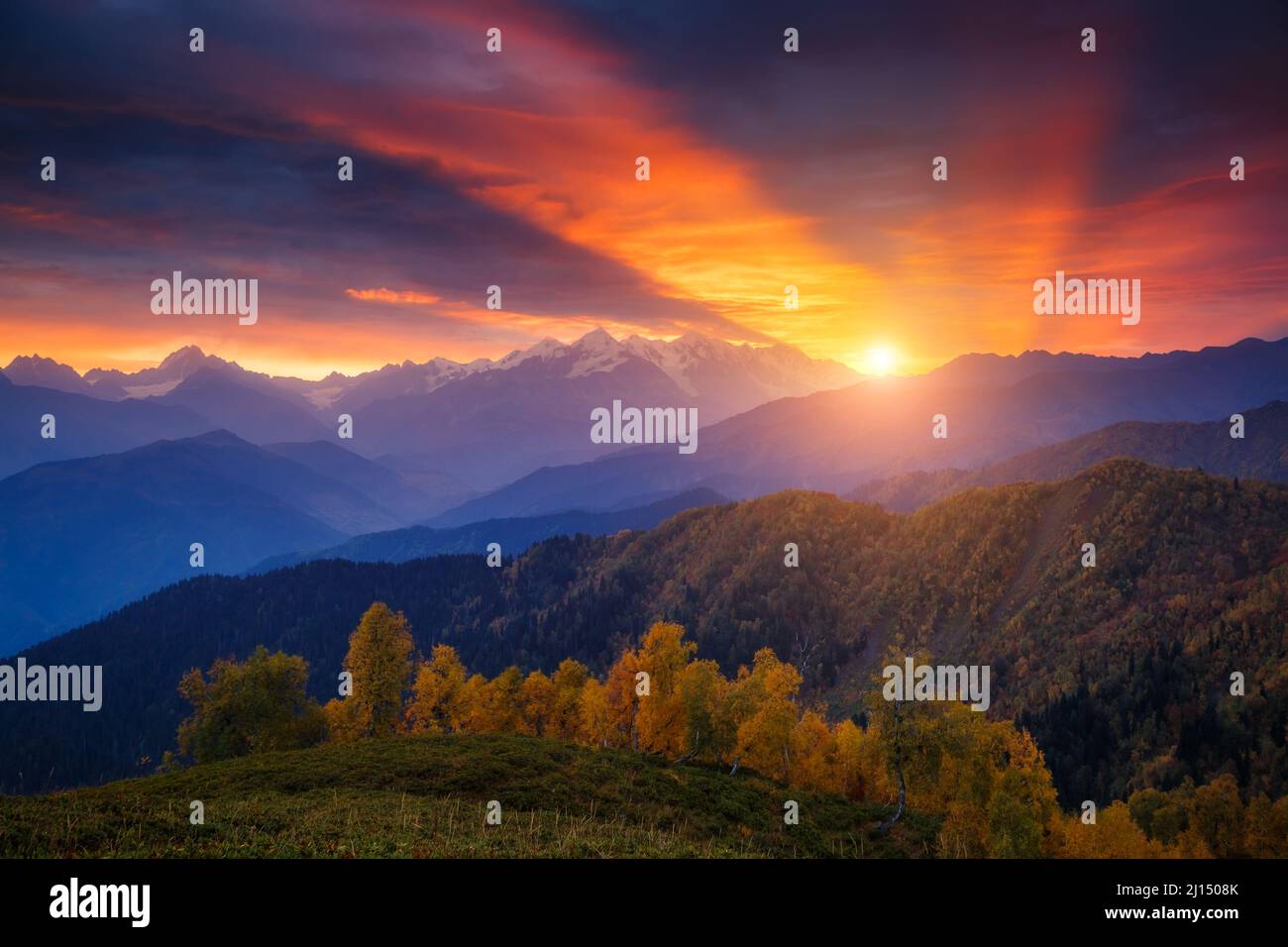Fantastic red sunbeams with overcast sky at the foot of Mt. Ushba ...