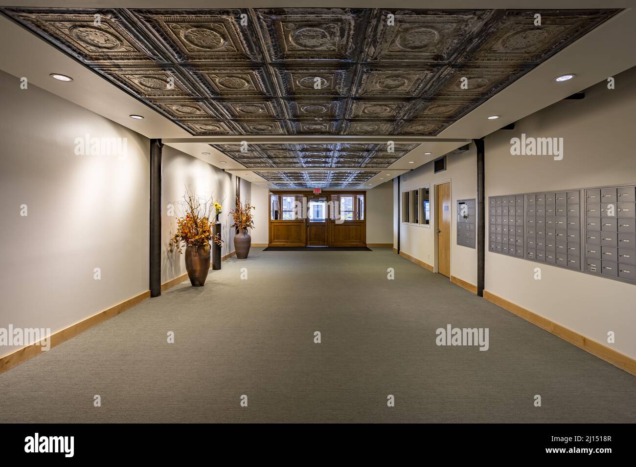 Beautiful building lobby interior with silver postboxes and a ceiling ...