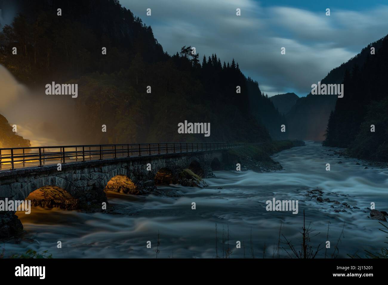 Eerie view of a bridge over the river in the evening at the bottom of ...