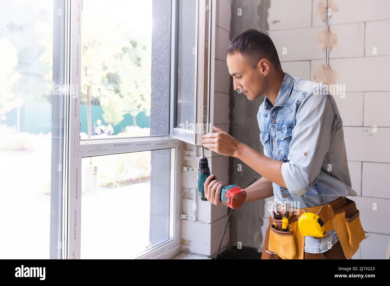 Construction worker installing window in house Stock Photo - Alamy