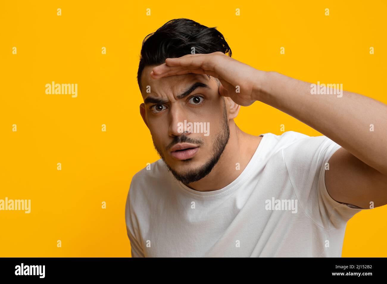 Confused guy holding hand by forehead and looking at camera Stock Photo ...