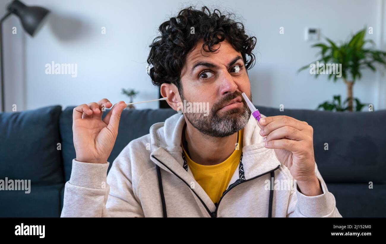 Funny expressive man taking a self swabbing home tests for Covid19 with ...