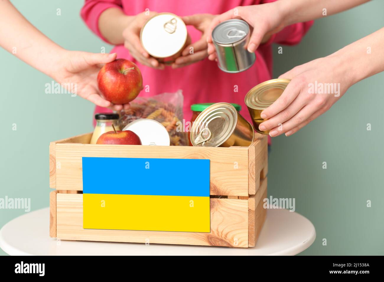 People putting donations in box on table. Humanitarian aid for Ukraine ...
