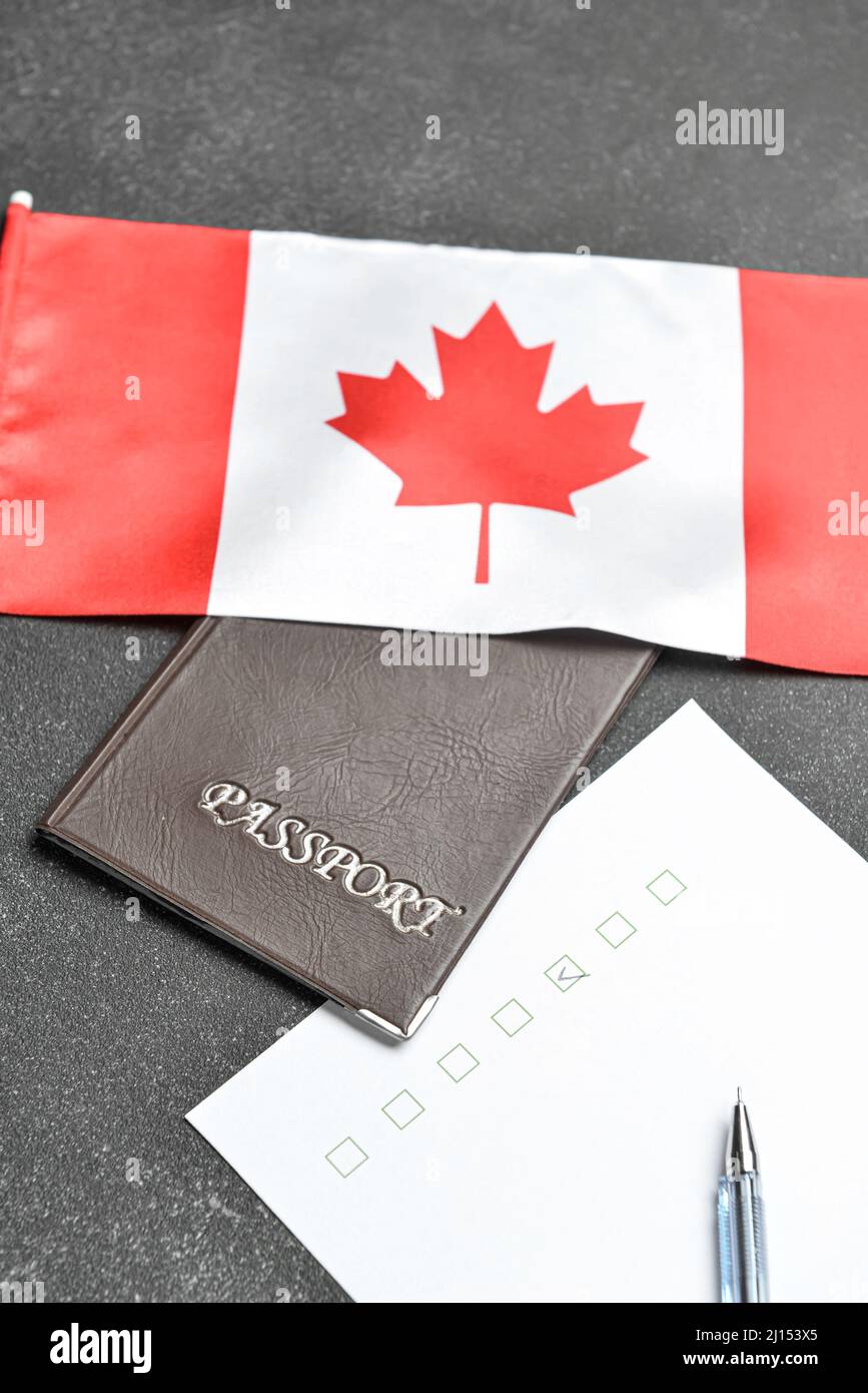 Canadian flag with passport, pen and voting sheet on dark background ...