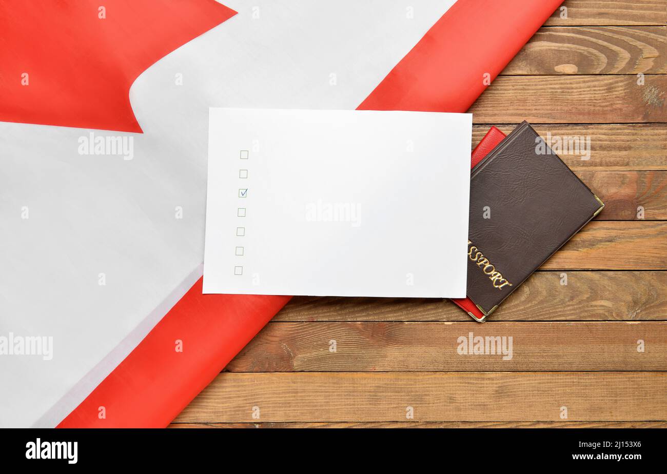 Voting sheet with passports and Canadian flag on wooden background ...