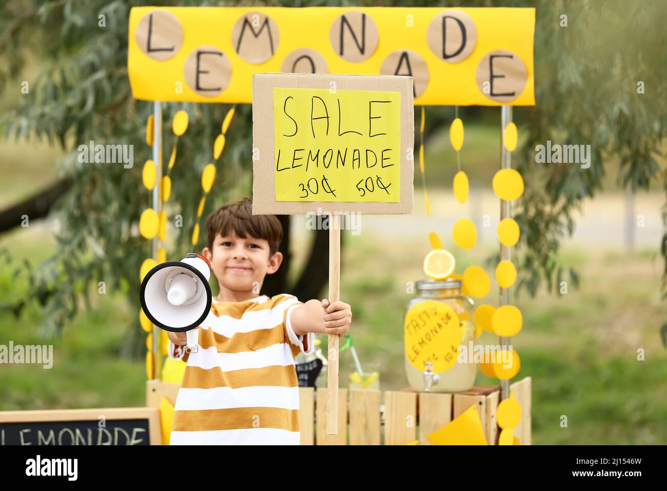 Cute boy with megaphone selling lemonade in park Stock Photo - Alamy