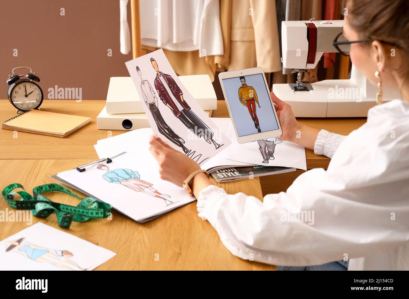 Young female clothes stylist working in studio Stock Photo - Alamy