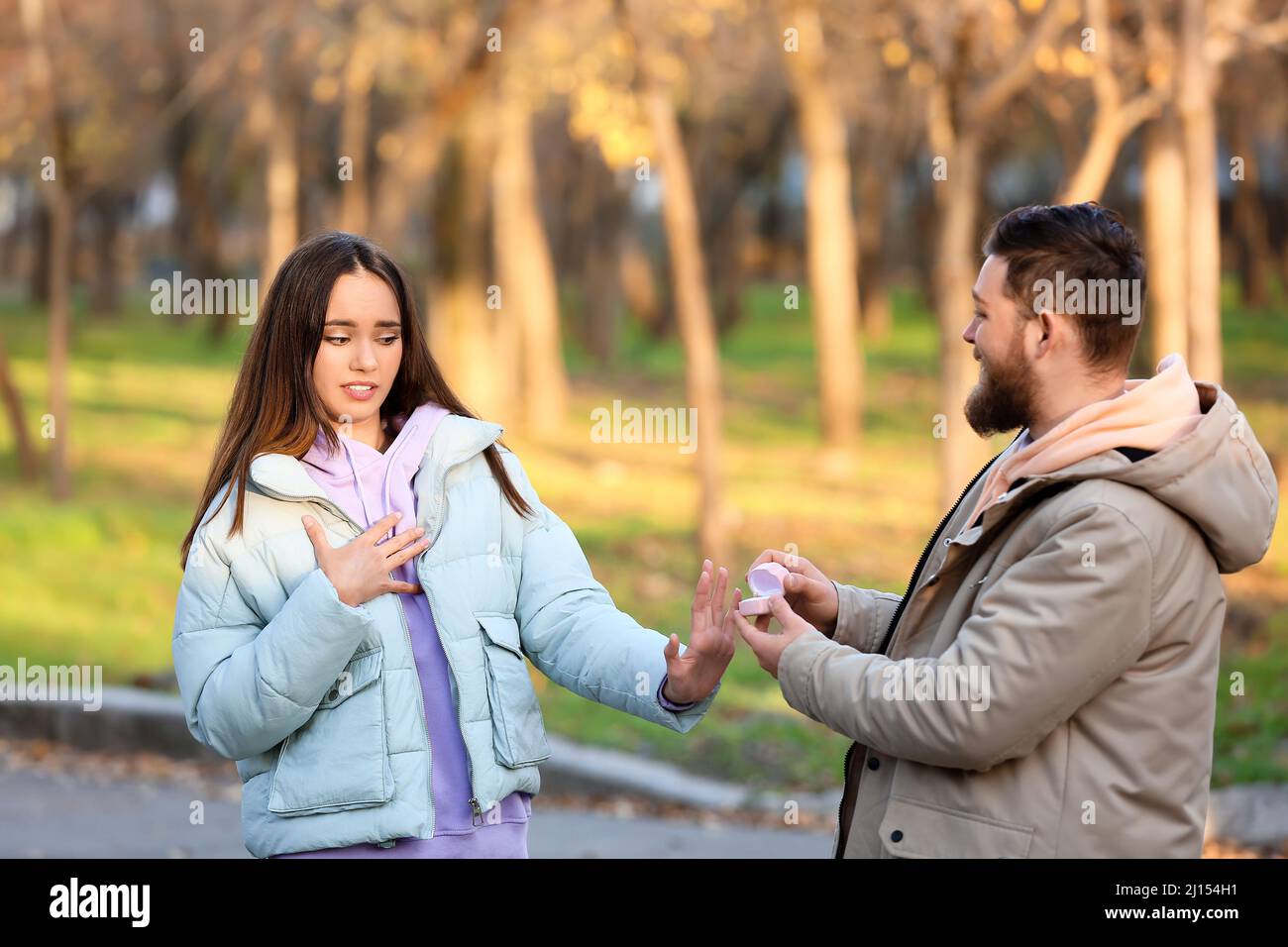 Young woman rejecting marriage proposal from her boyfriend in forest ...