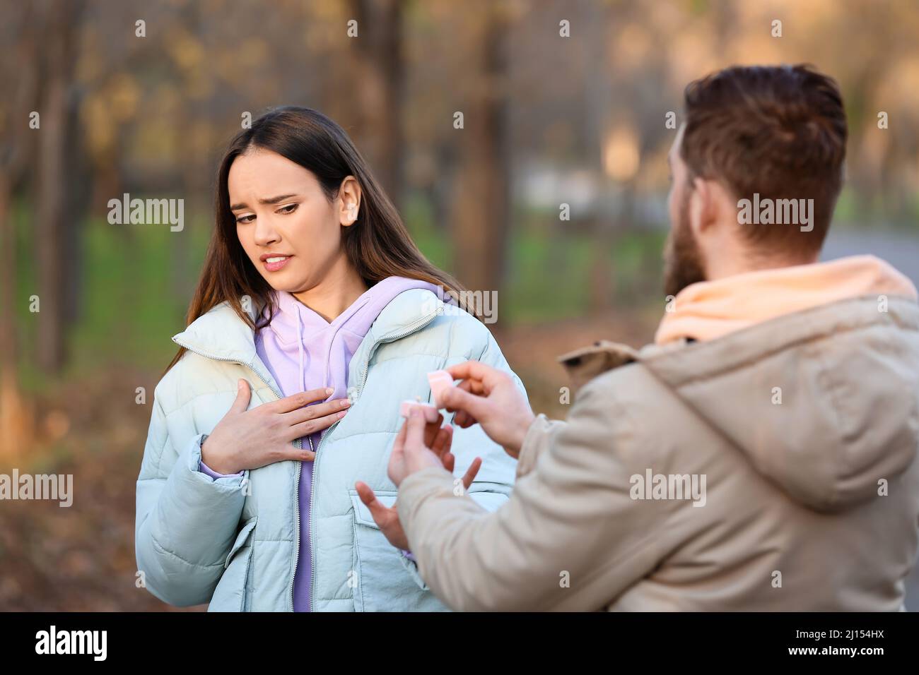 Young woman rejecting marriage proposal from her boyfriend in forest ...
