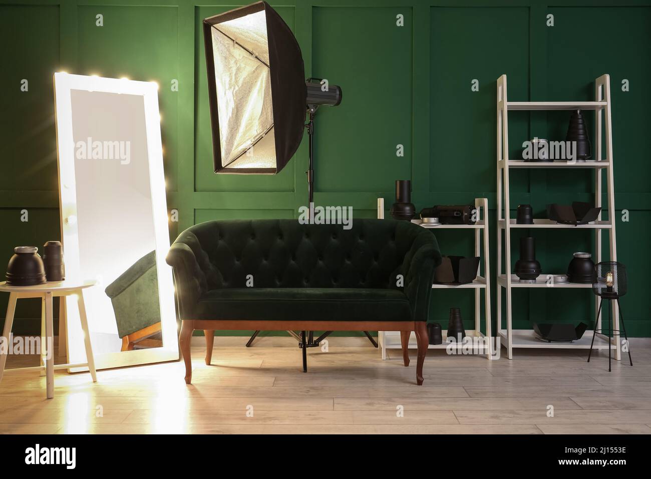 Interior of modern photo studio with sofa, glowing mirror and ...