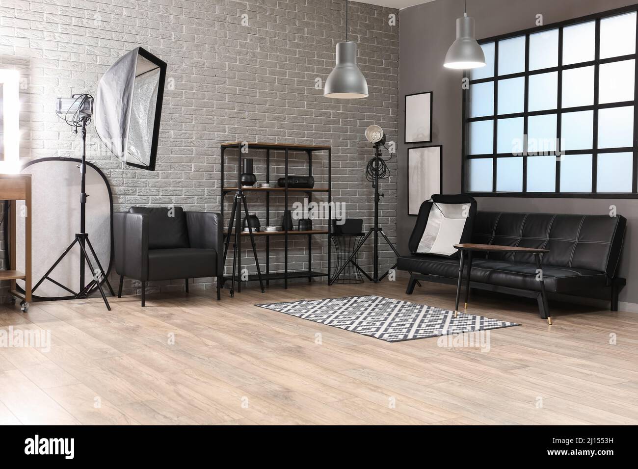 Interior of modern photo studio with shelving unit, couch and ...