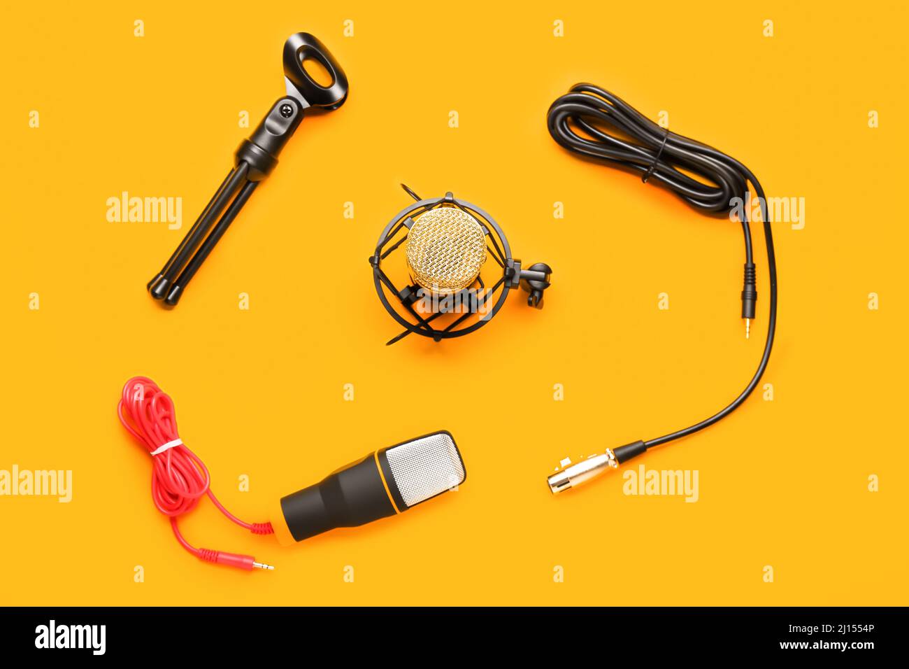 Modern microphones with stand and wires on orange background Stock ...