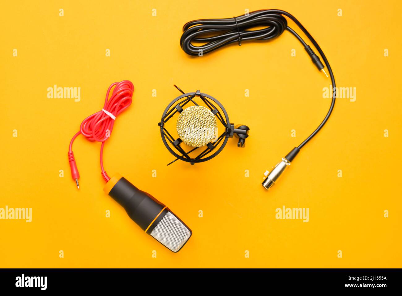 Modern microphones with stand and wires on orange background Stock ...