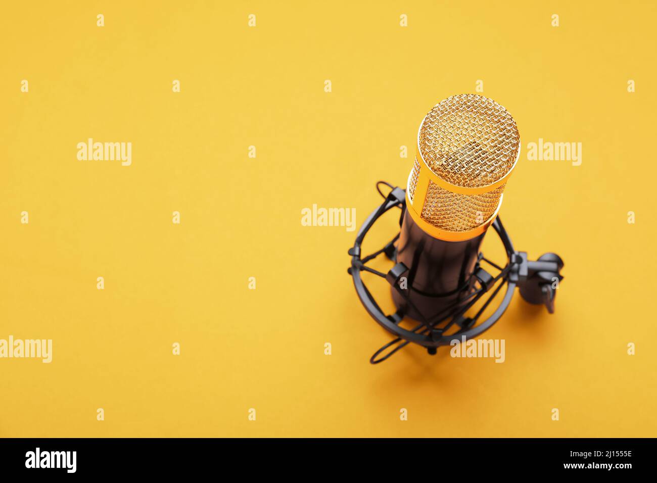 Stand with modern microphone on orange background Stock Photo - Alamy