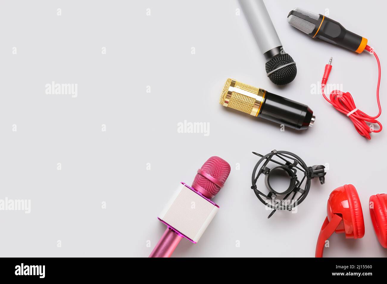 Modern microphones with headphones on light background Stock Photo - Alamy