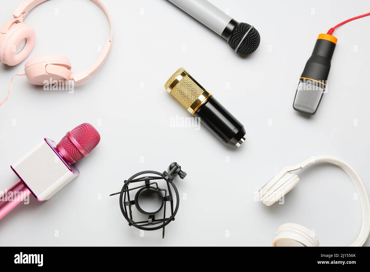 Modern microphones with headphones on light background Stock Photo - Alamy