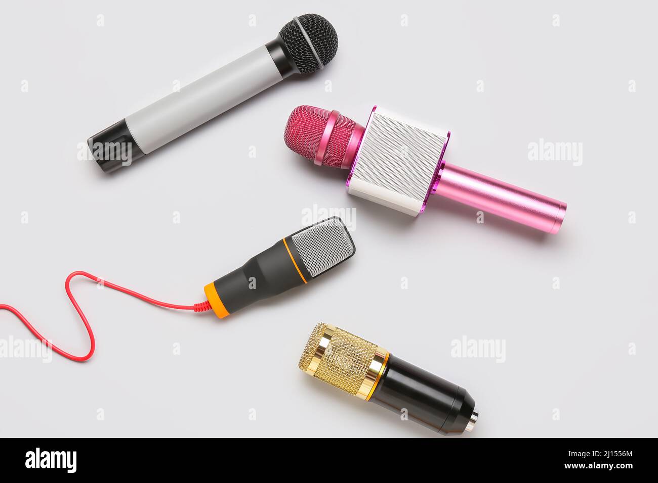 Different modern microphones on light background Stock Photo - Alamy