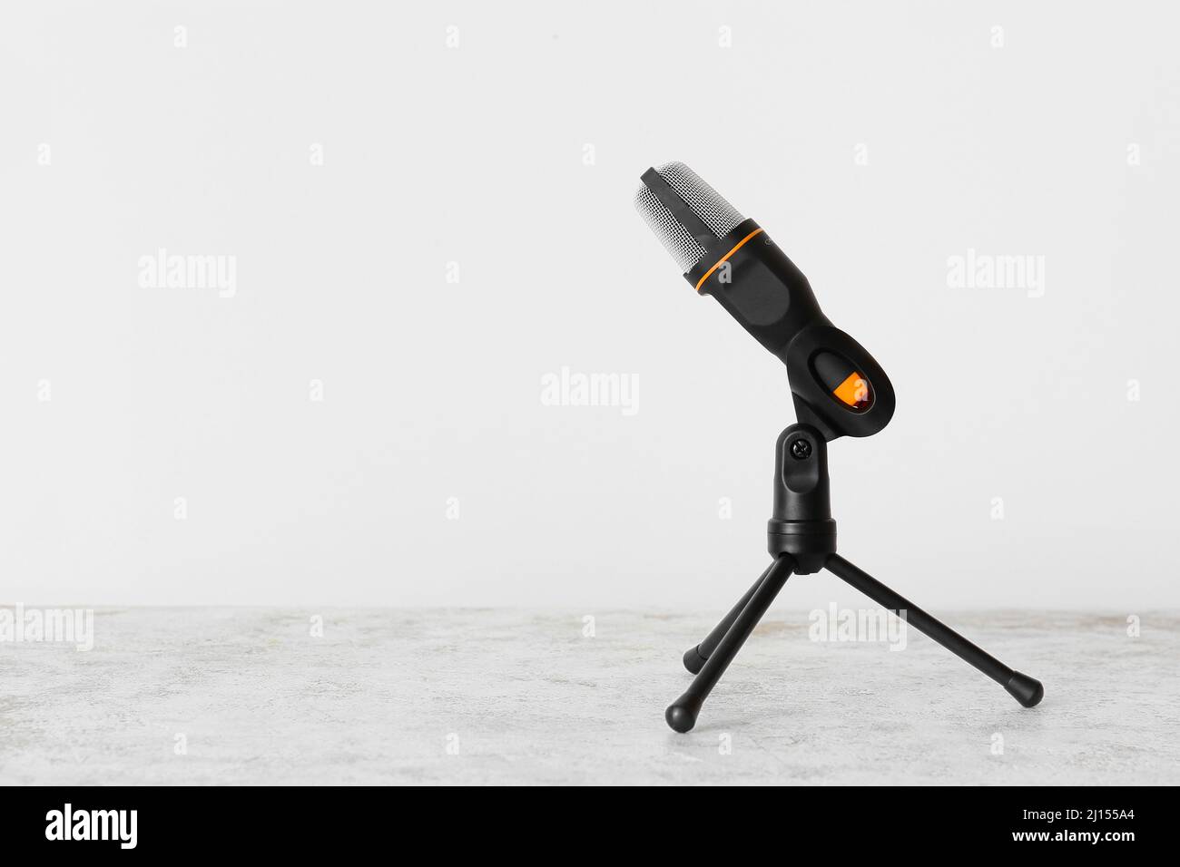 Stand with modern microphone on light background Stock Photo - Alamy