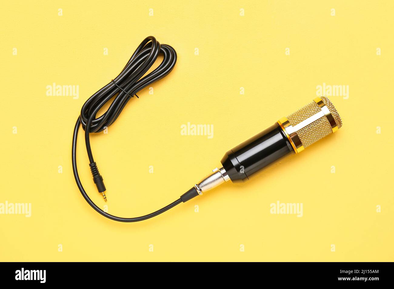 Modern microphone with wire on color background Stock Photo - Alamy