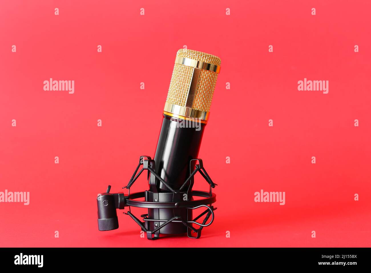 Stand with modern microphone on red background Stock Photo - Alamy