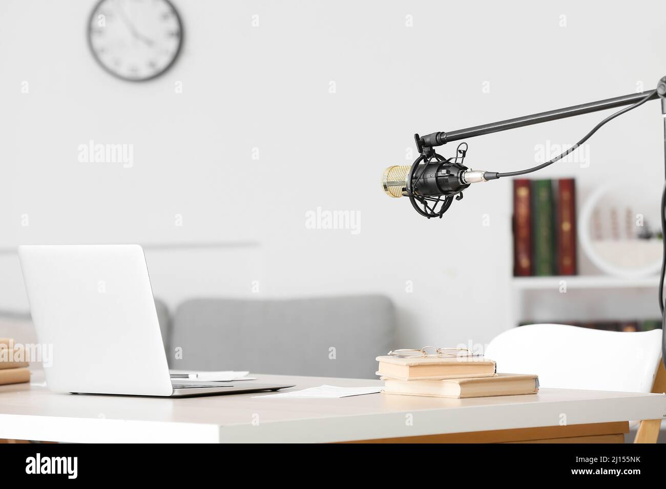 Modern workplace with laptop, books and microphone in room Stock Photo ...