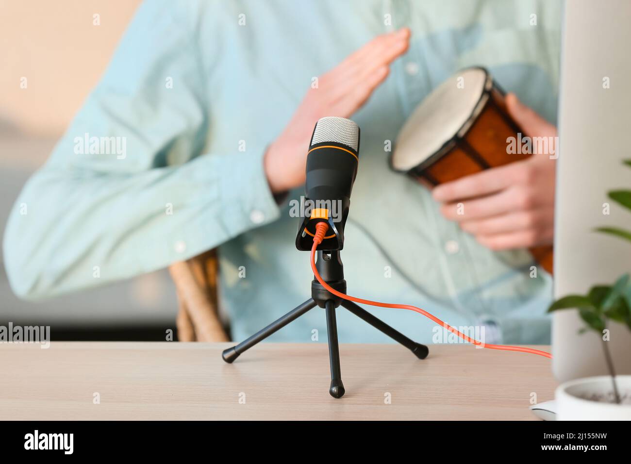 Modern microphone on table of man playing drum in room, closeup Stock ...