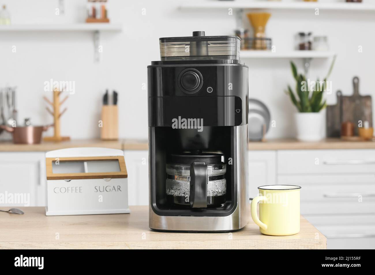 Modern coffee machine and cup on counter in kitchen Stock Photo - Alamy