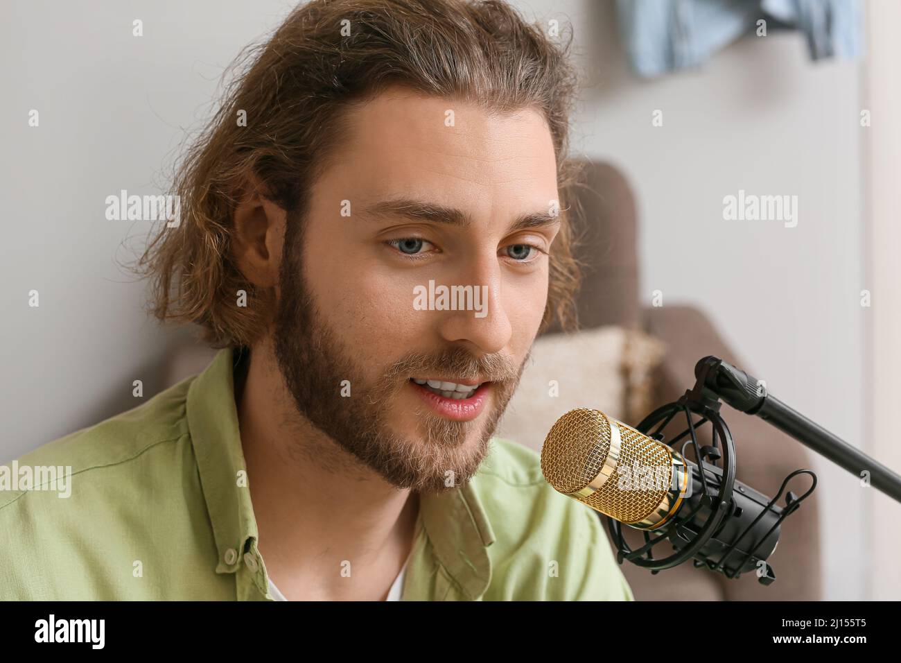 Handsome man using microphone at home Stock Photo - Alamy