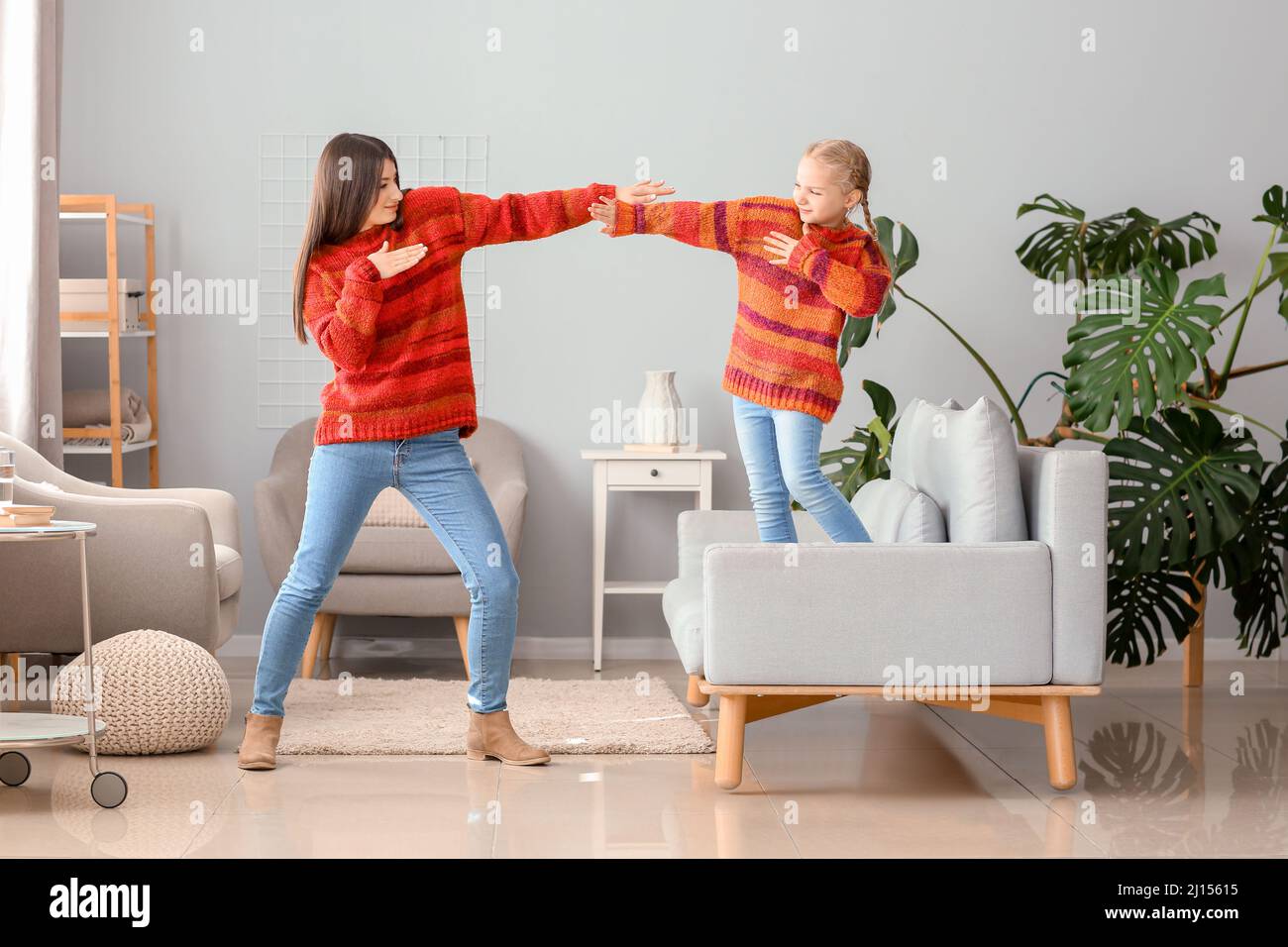 Little girl and her mother in warm sweaters dancing at home Stock Photo ...