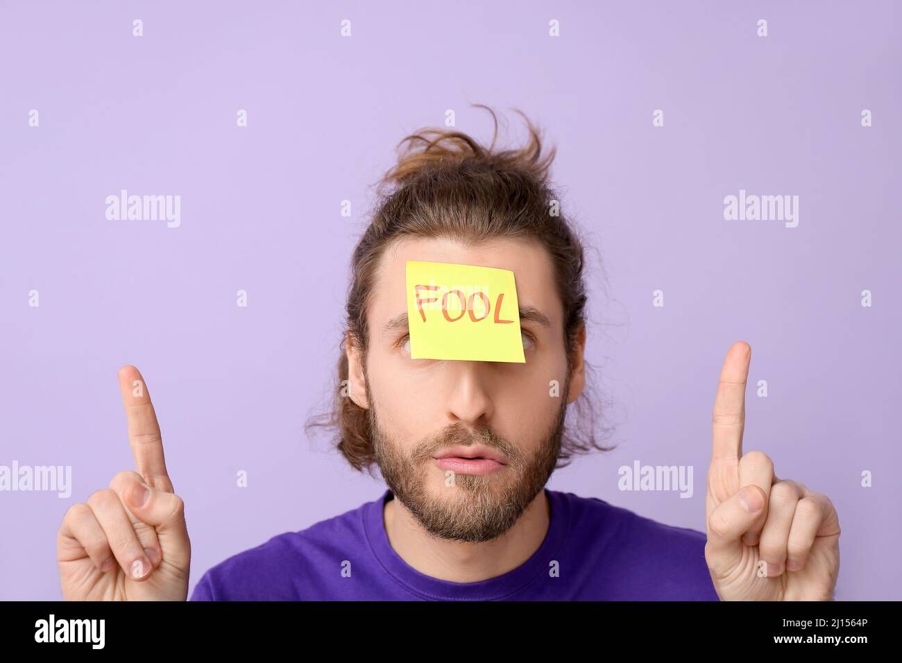 Funny man with sticky note on his forehead showing something against ...