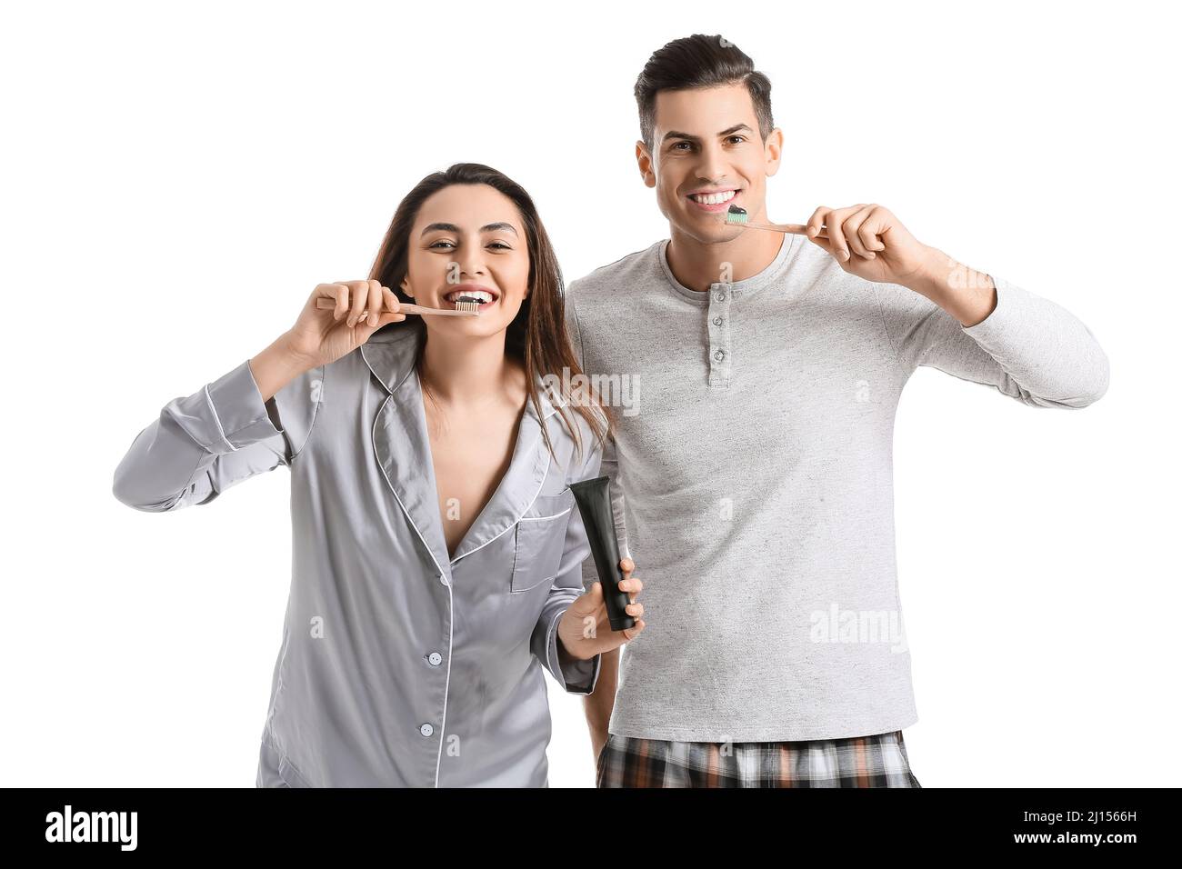 Young couple brushing teeth with activated charcoal tooth paste on ...