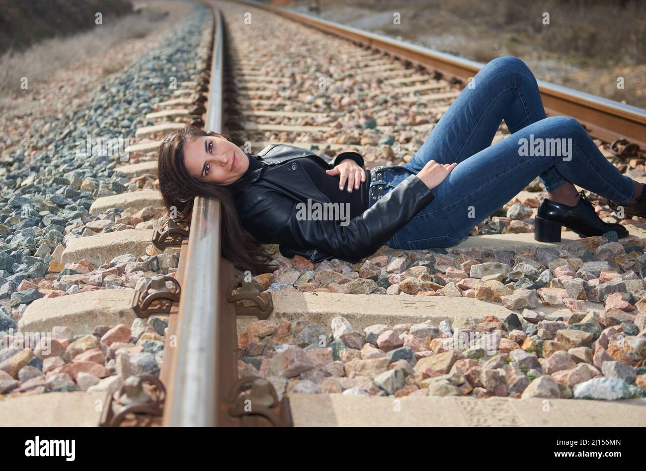 An attractive girl lying quietly on the rails of the train Stock Photo ...