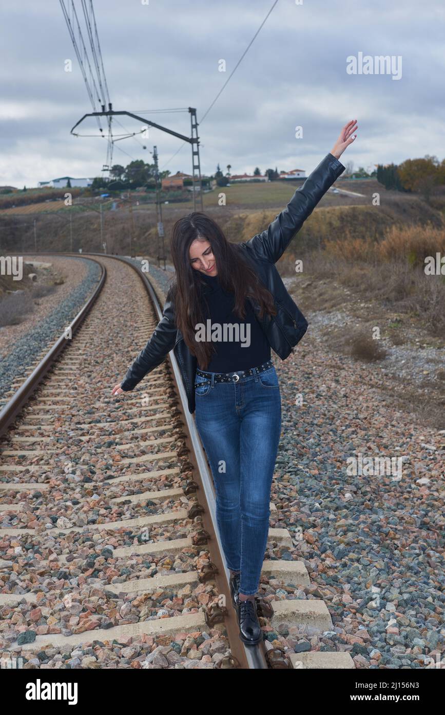 A daring and beautiful woman balancing on train rails Stock Photo - Alamy