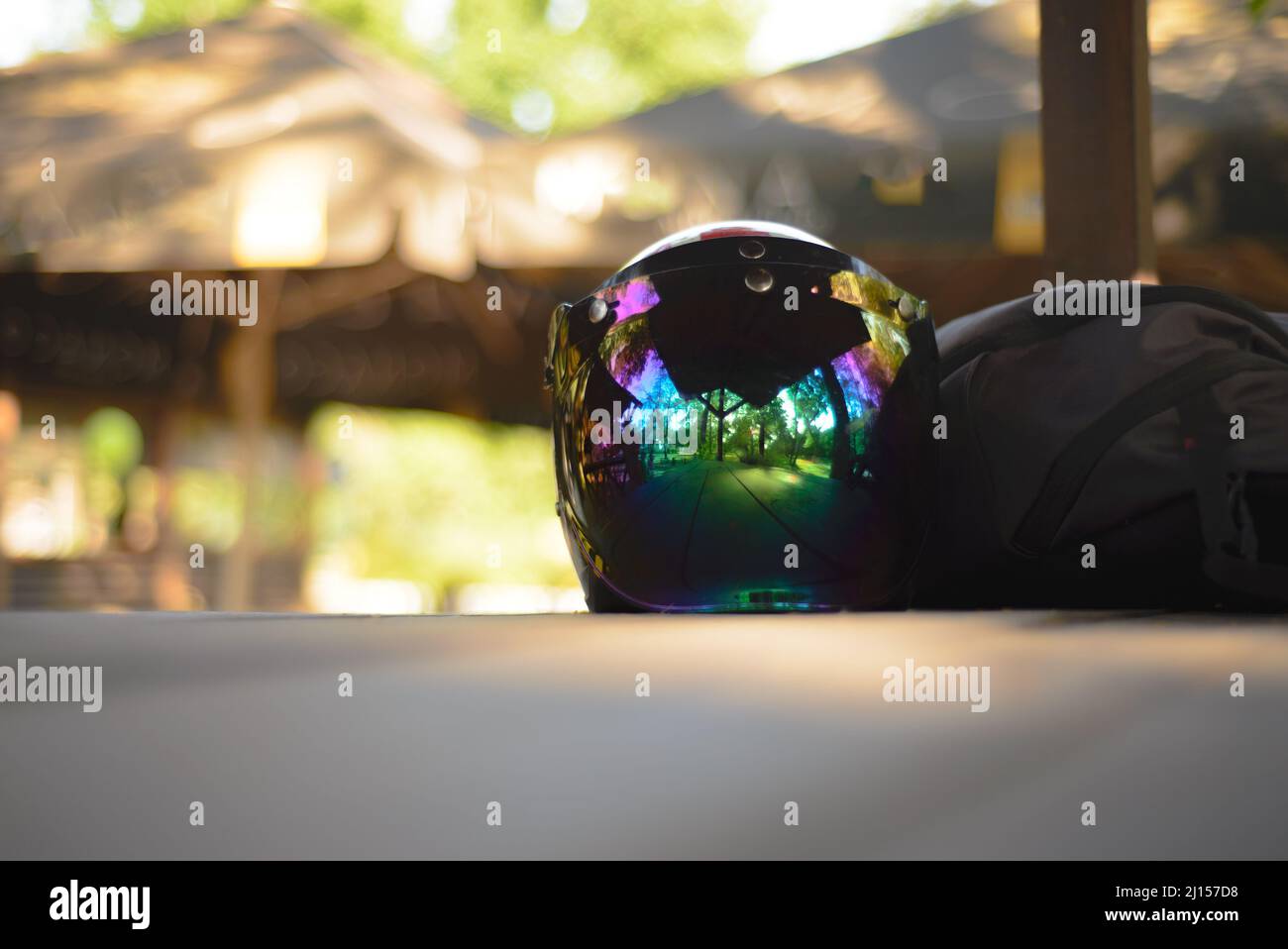 A motorcycle helmet with a mirror visor lies on the table with a ...