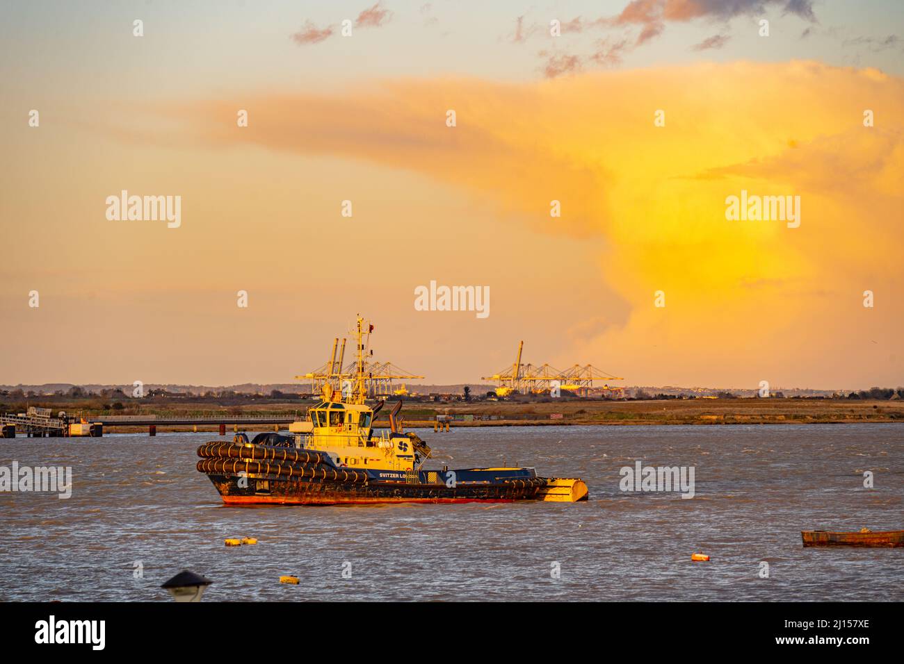 Tug boat moored in the river Thames, off Gravesend with dramatic clouds ...
