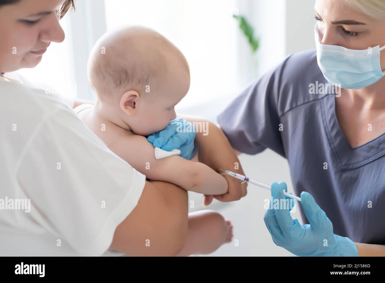 Pediatrician doctor with syringe, tense mother and baby Stock Photo - Alamy
