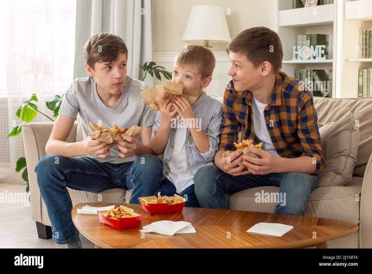 A happy three teenage boys, eating fast food Stock Photo - Alamy