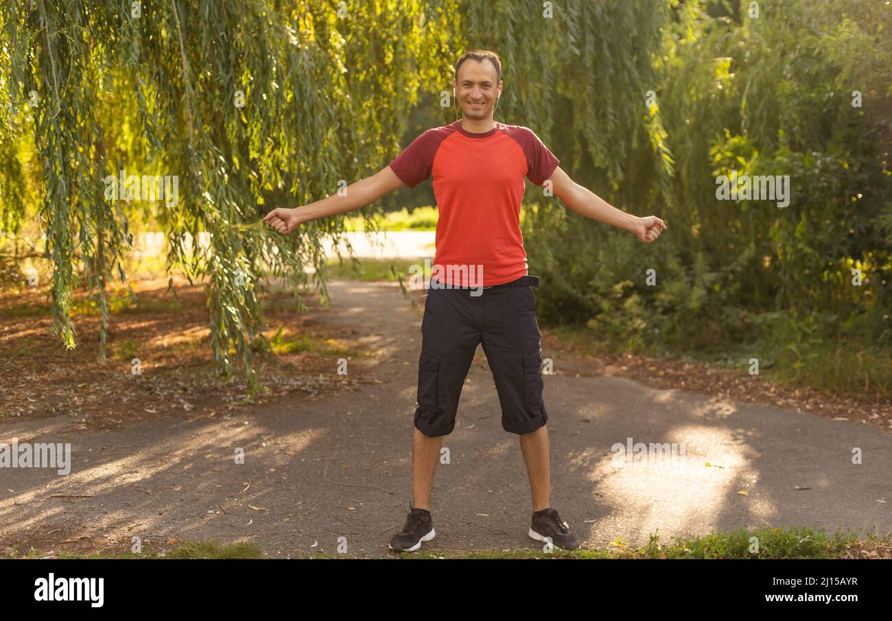 Successful man raising arms after cross track running on summer Stock ...