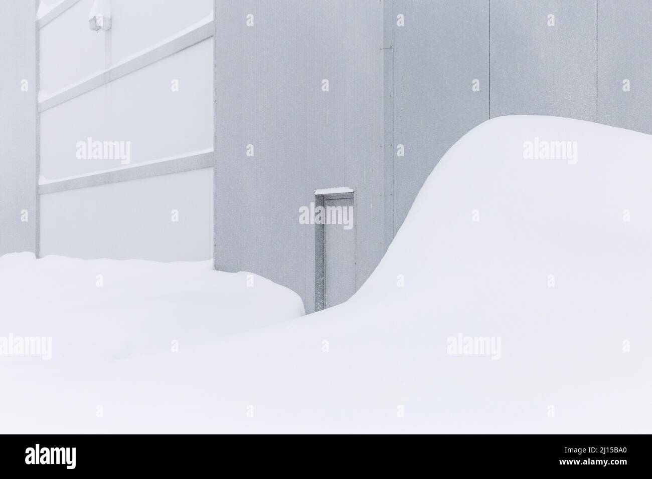 A snowdrift up against a building during the winter, in Longueuil ...