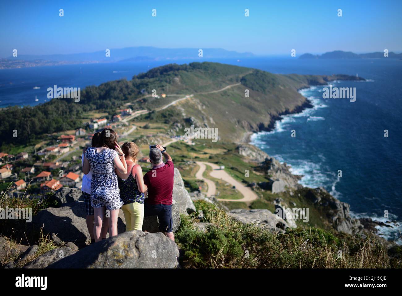 Group of tourists hiking in Facho de Donon cliffs, with Costa de la ...