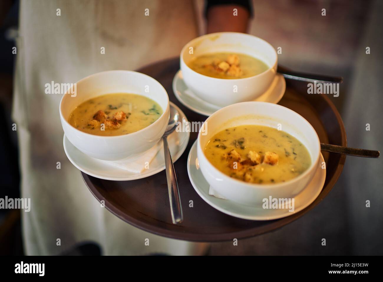 Here comes the starters. Closeup of an unrecognizable waiter holding a ...