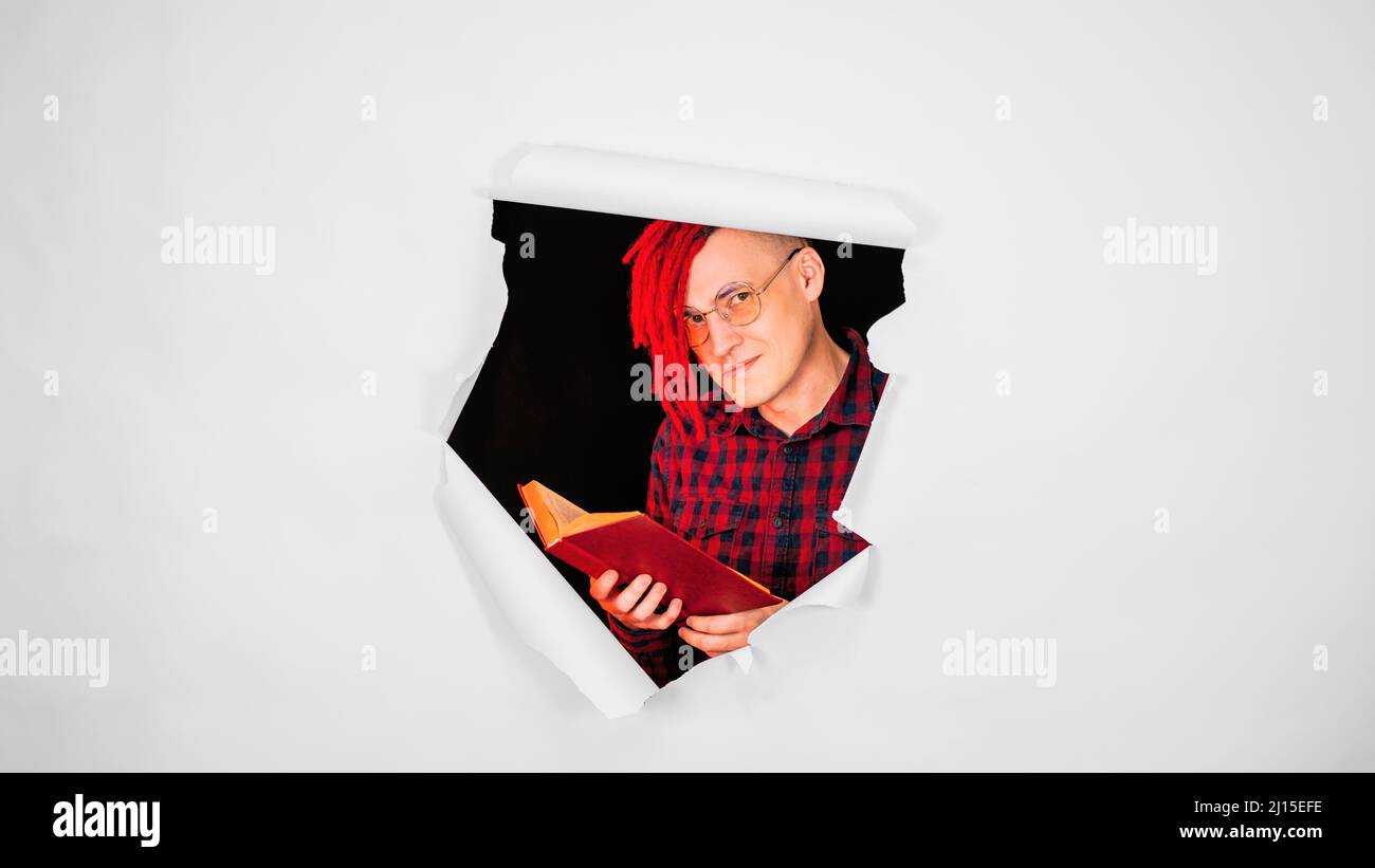 Man in red plaid shirt with bright hairstyle reading book and sticking ...