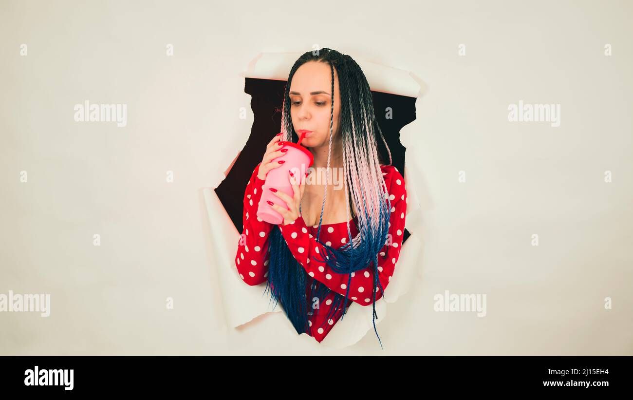 Female bartender with dreadlocks and cup of sweet beverage peeking ...